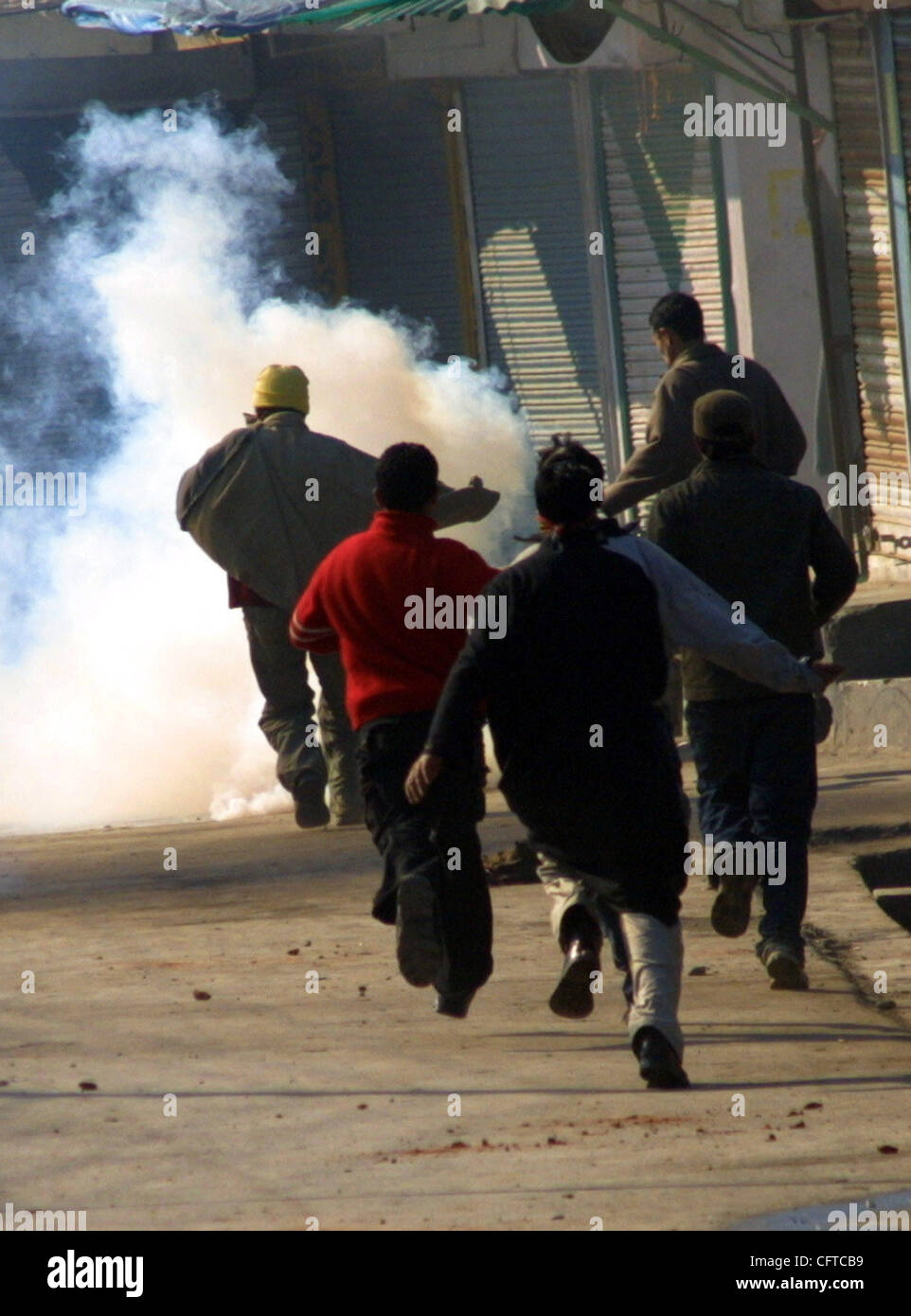 A tear smoke shell explodes near two Kashmiri protesters during a clash ...