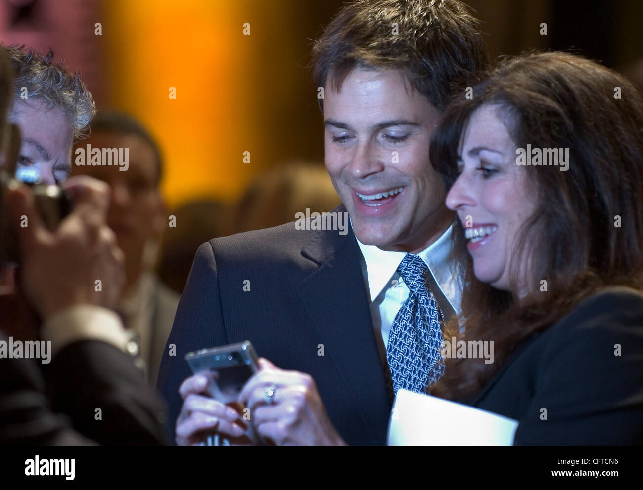 Actor Robert Lowe, center, is hit with flashes as photograhpers try to ...