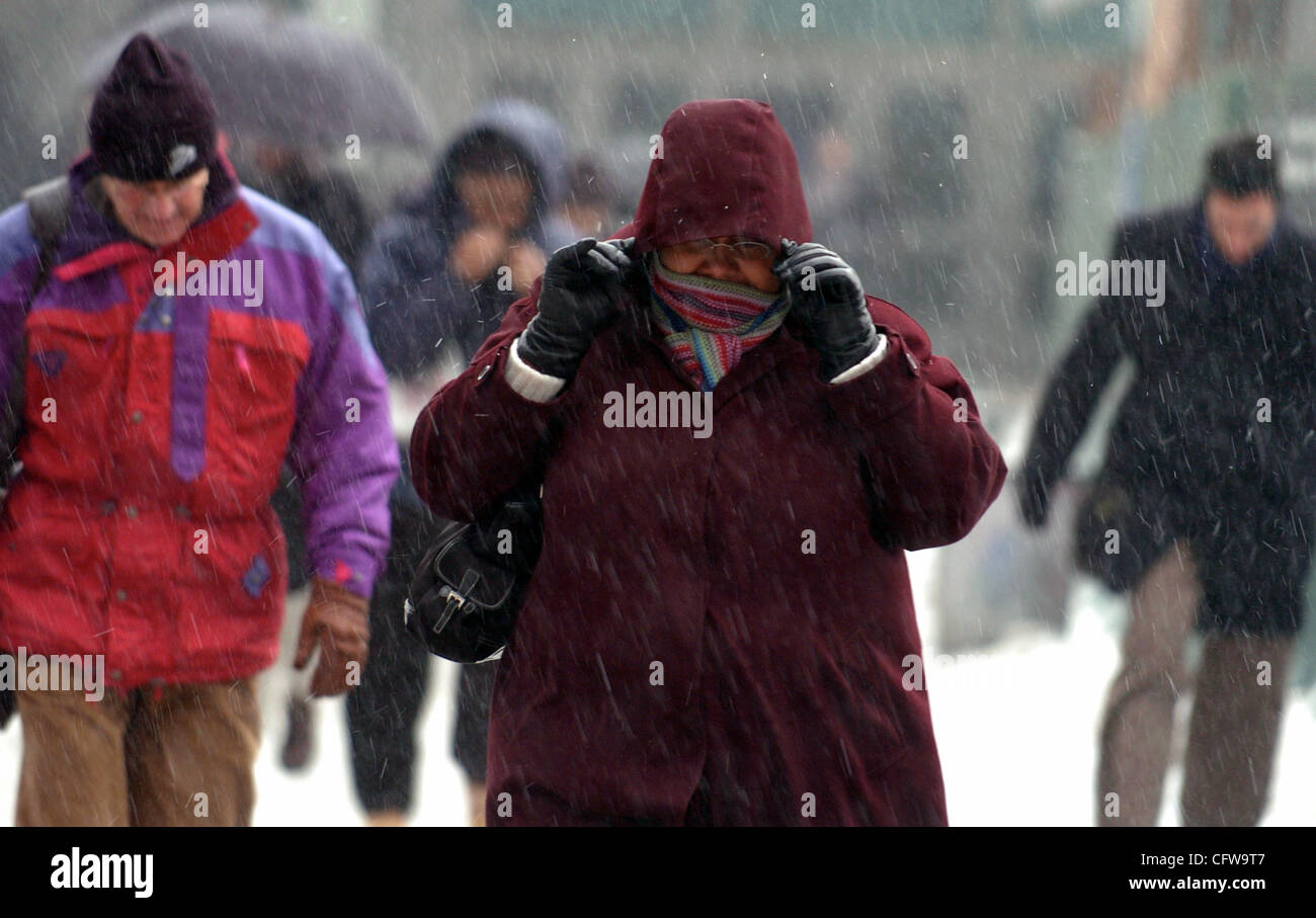 A woman tries to shield herself from the wind and ice in lower ...