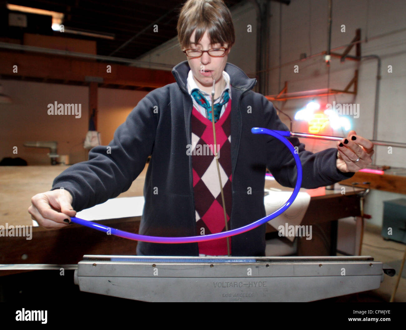 Amy Palms, Neon tube glass bender and artist, works on bending a glass ...