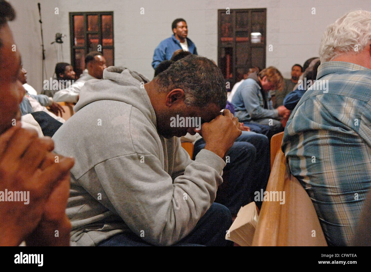 Inmate in prayer during evening worship service, Louisiana state ...