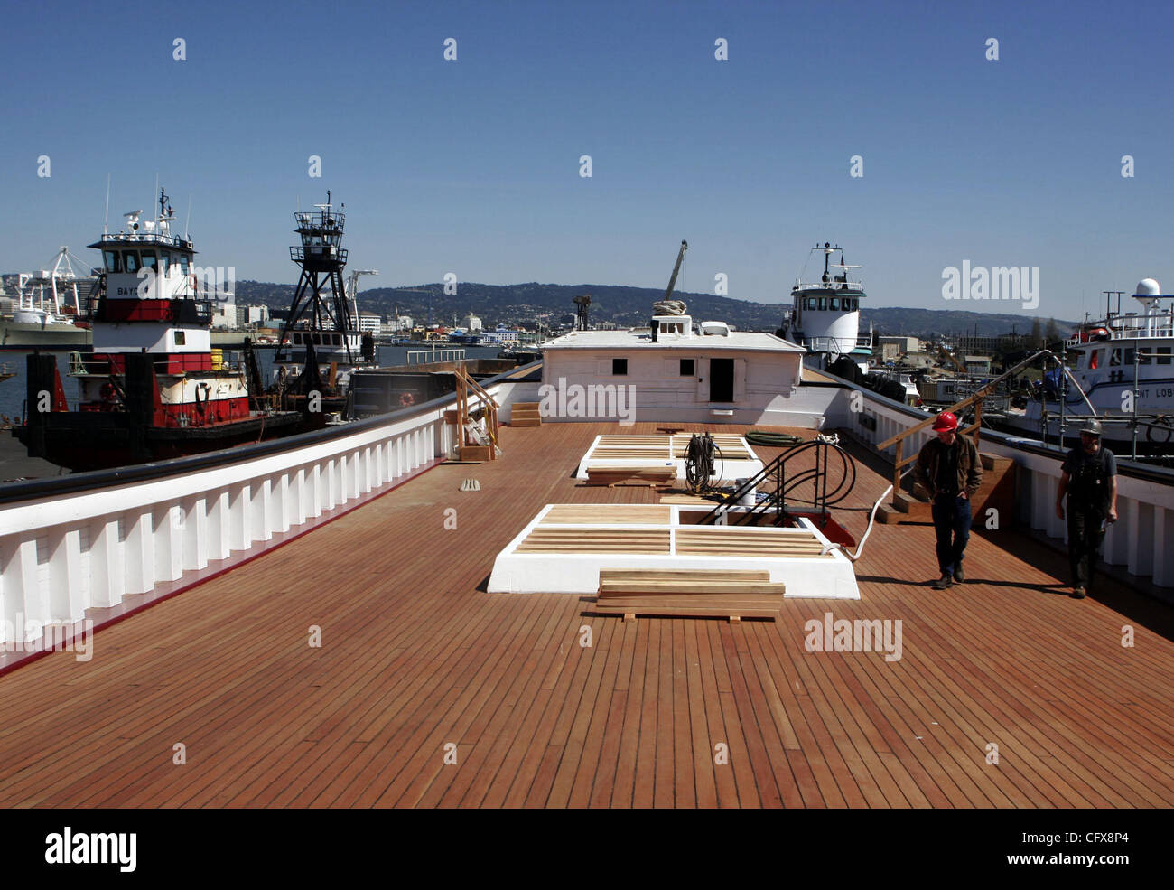 Workers walk on the deck of the C.A. Thayer at the Bay Ship & Yacht ...