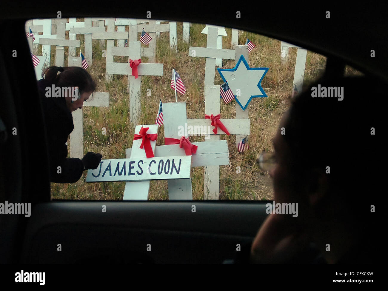 Yvonne Ramos, from Alameda, writes the name James Coon on a cross as ...