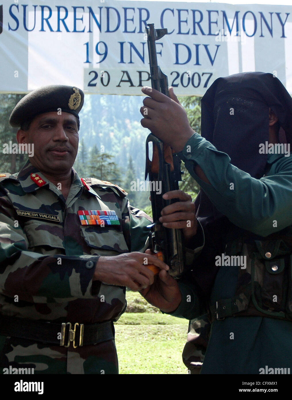 A suspected militant hands over his weapon to an Indian army officer ...