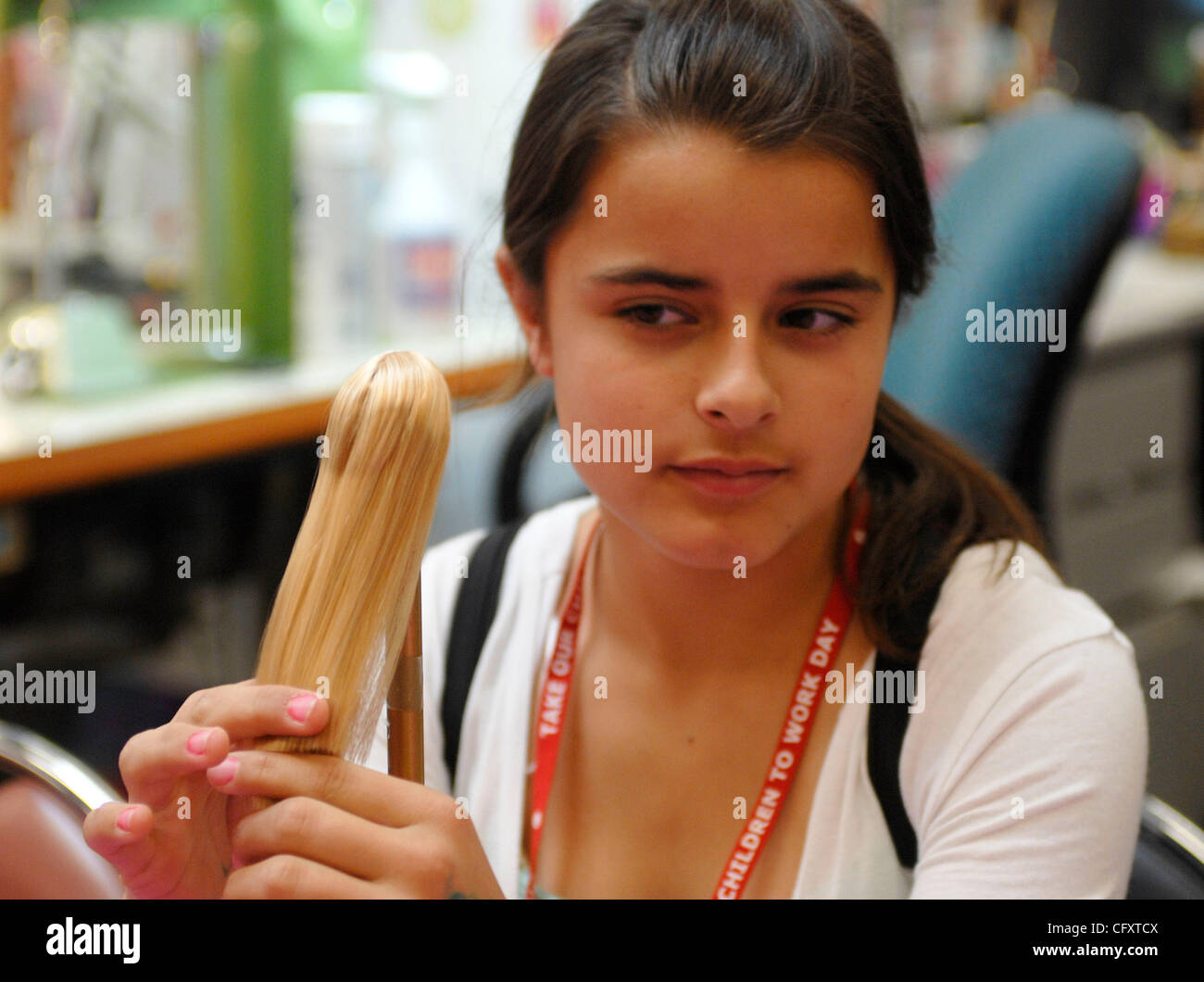 VICTORIA JOHNSON works with the hair of a Barbie that she is designing ...