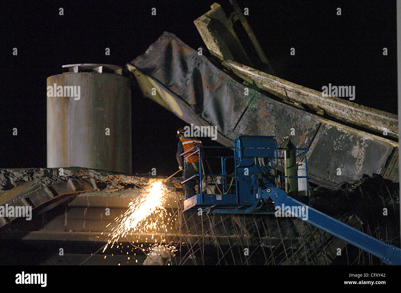 A worker helping with the initial clean-up process on the collapsed ...