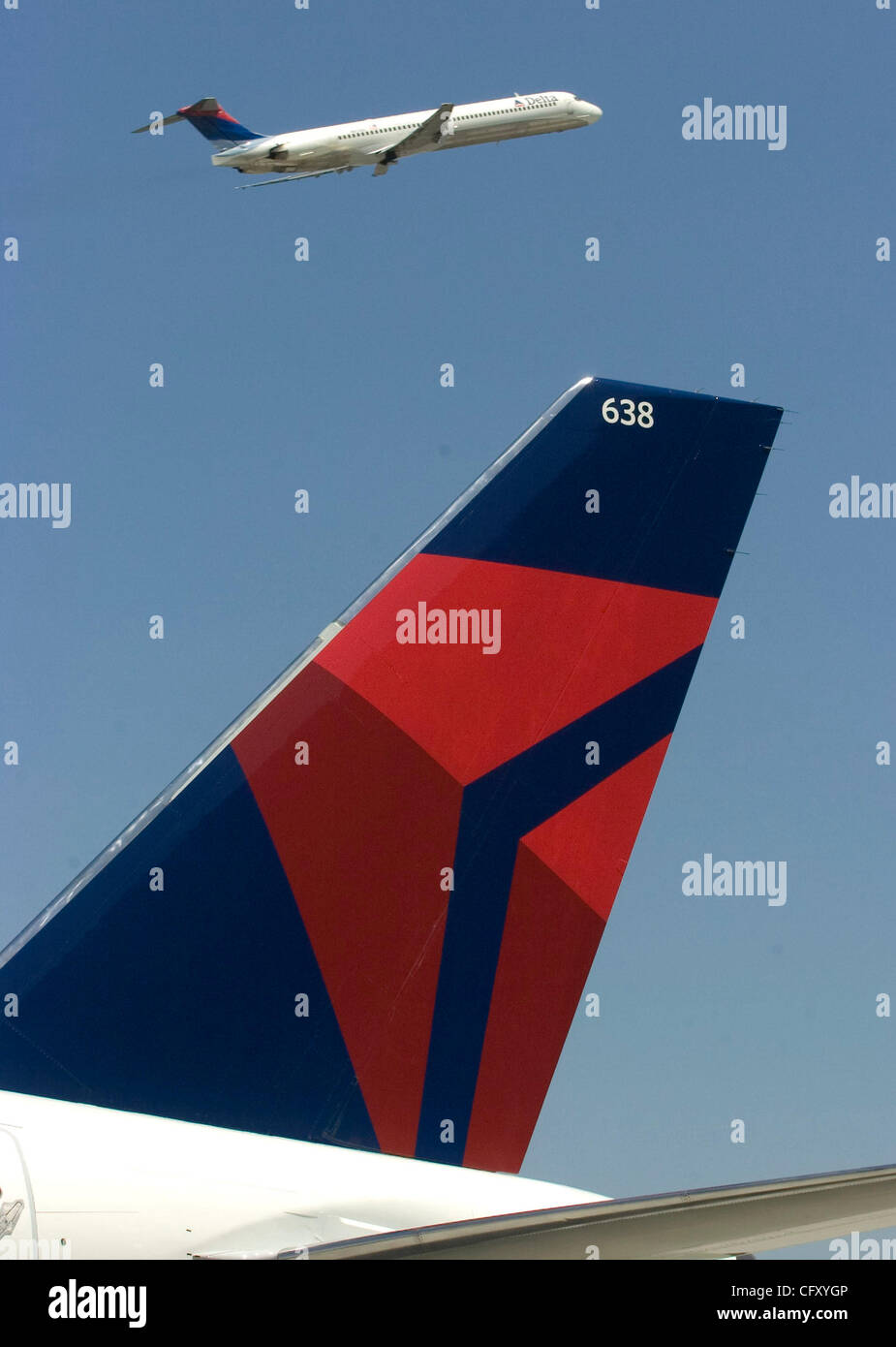 A Delta Air Lines jet takes off past the newly painted tail of another ...