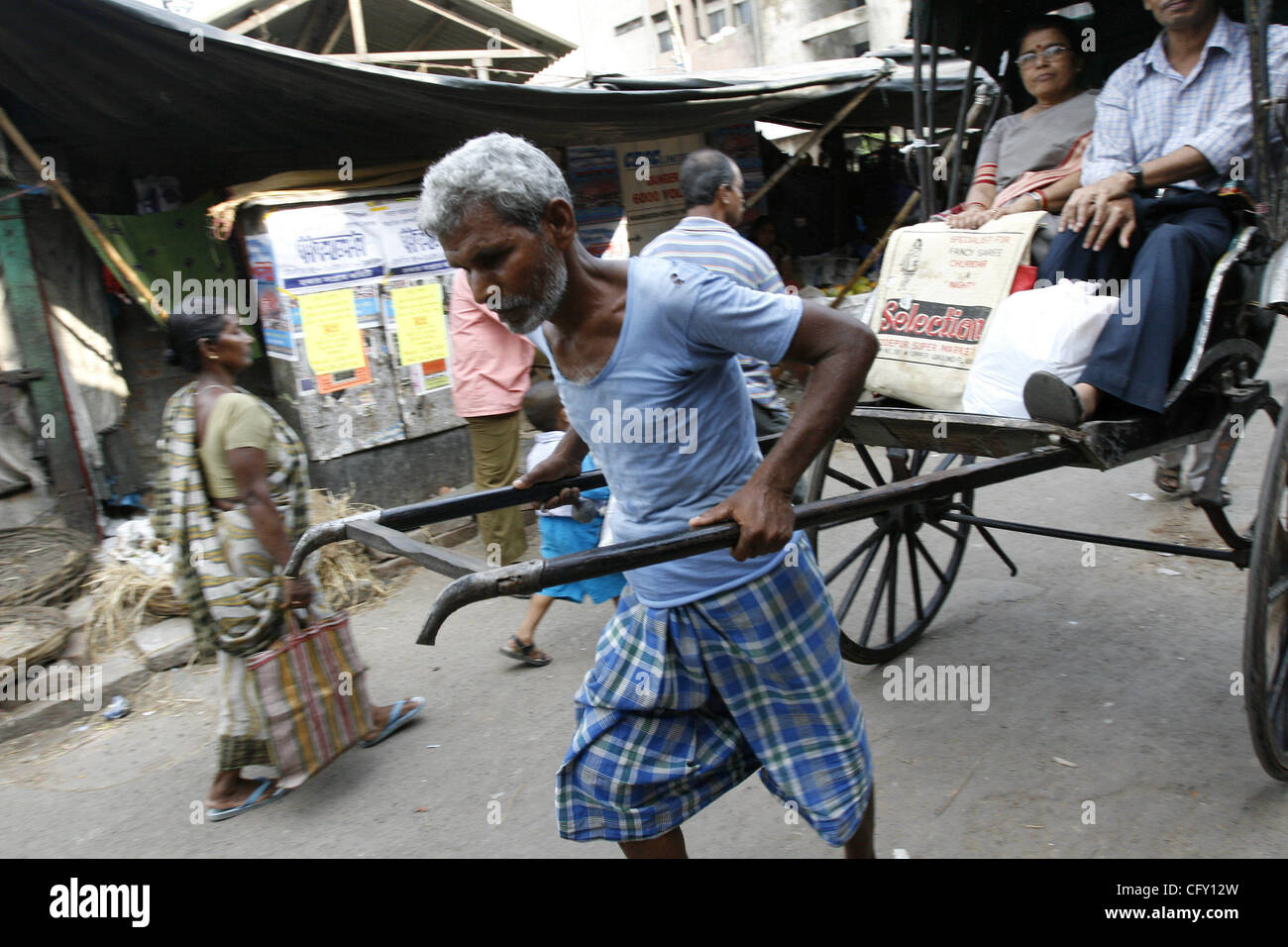 A rickshaw puller carrying a customer on the occasion of International ...