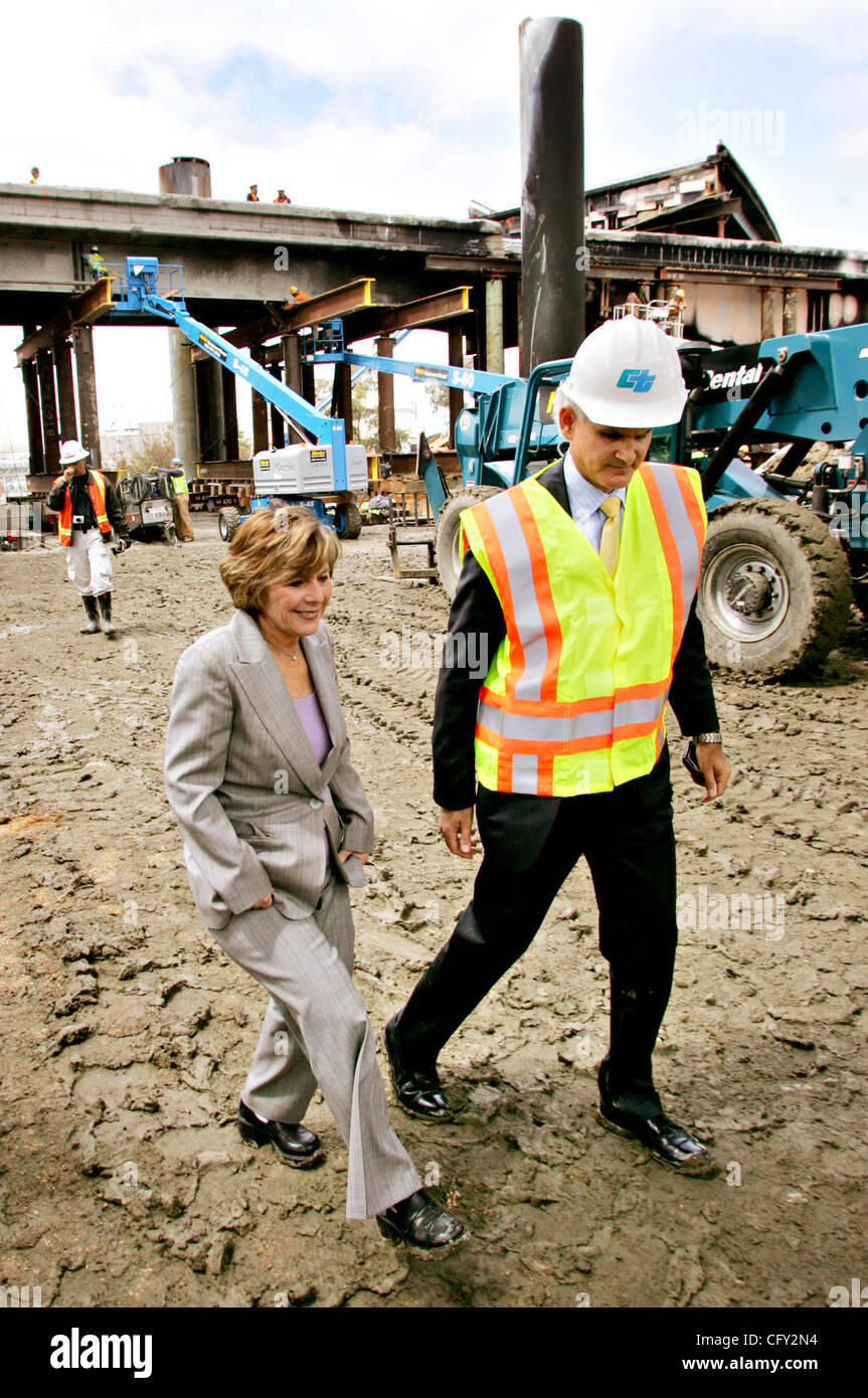 Senator Barbara Boxer is escorted throught the muddy construction site ...