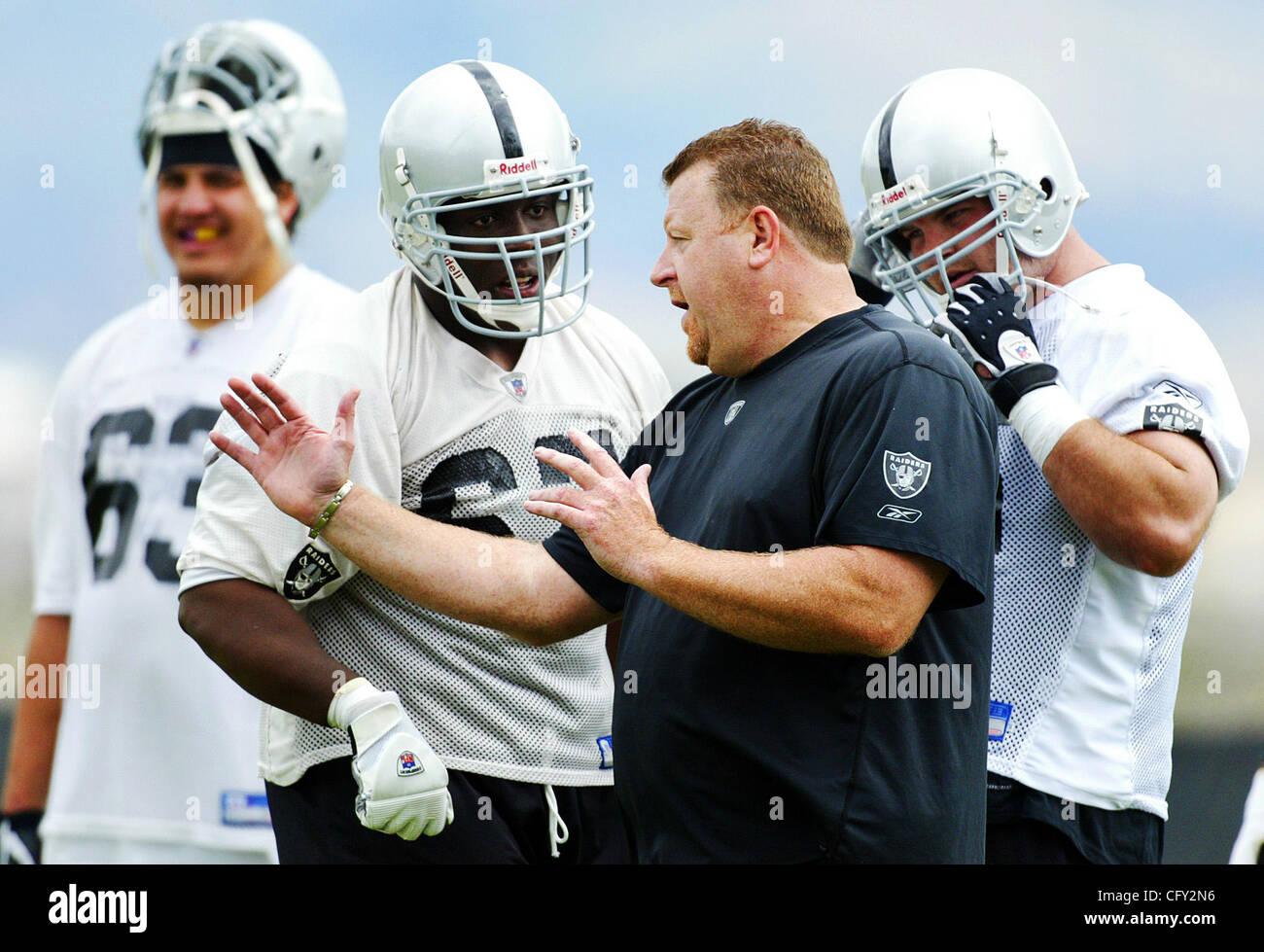 Offensive line coach Tom Cable talks with lineman Kevin Boothe (67) and ...