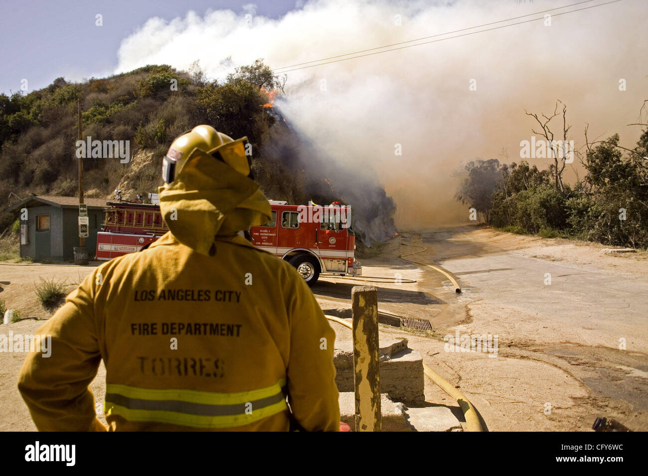 A firefighter watches a brush fire in Griffith Park, Los Angeles ...