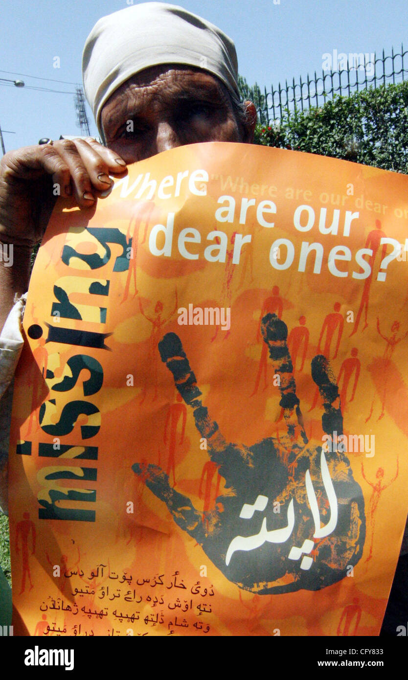 Mother of a missing Kashmiri youth holds a Poster during a ...