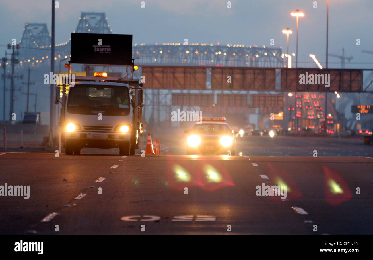 Caltrans workers, left, pick up orange cones guided by a CHP vehicle ...