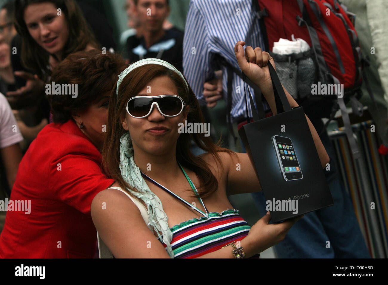 a girl holds up the one iphones he purchased at the apple store in new ...
