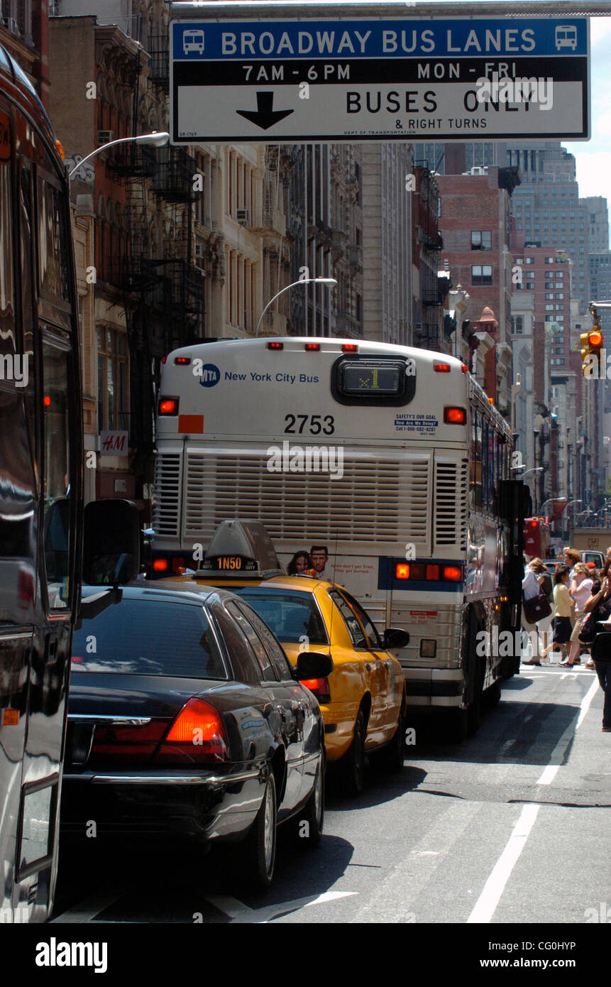 Traffic moves beneath a sign indicating a new bus only lane along ...