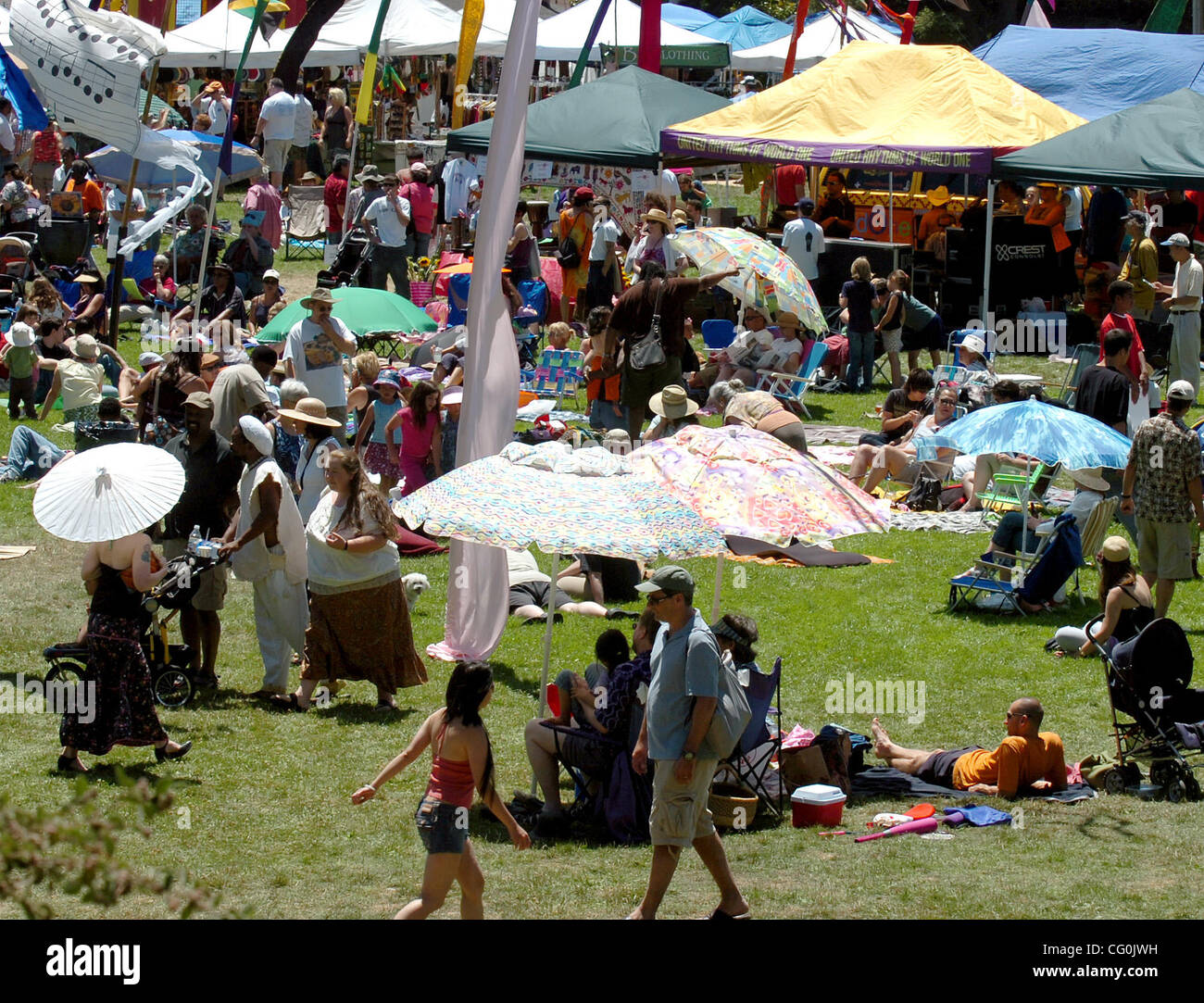 A big crowd of people enjoy the nice sunny weather, music and ...