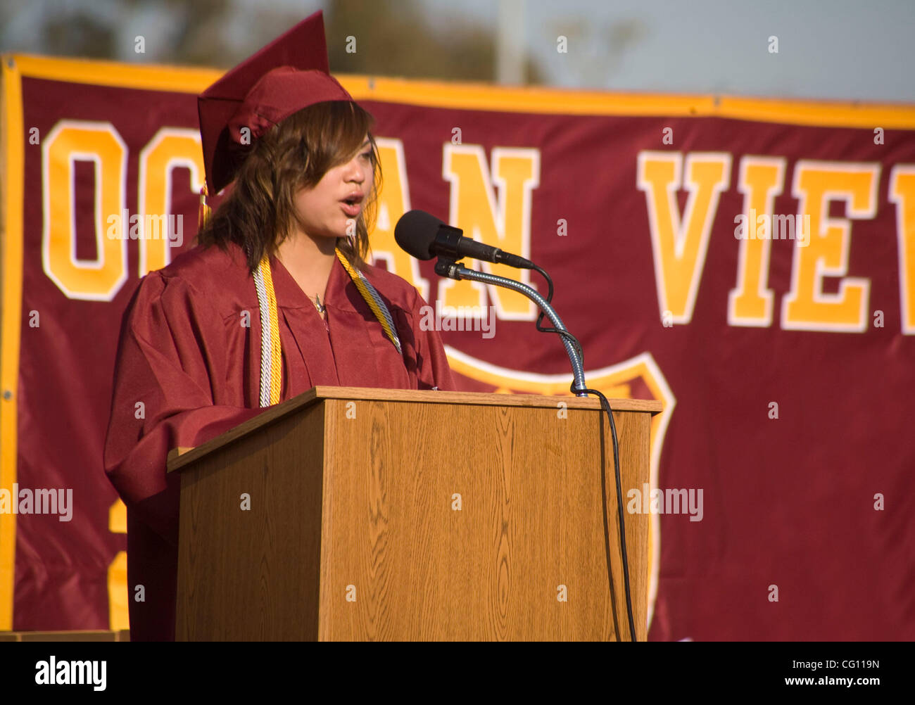 Wearing cap and gown, a Hispanic high school senior class valedictorian ...