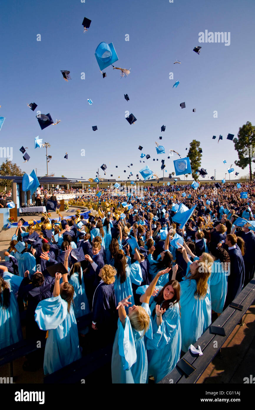 Graduating high school seniors throw their traditional caps in the air ...
