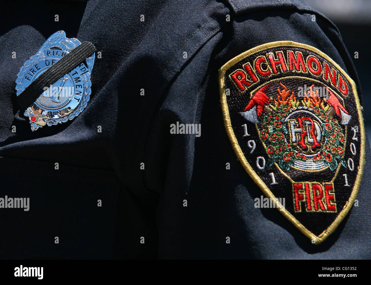 A black ribbon decorates the badge of Richmond Firefighter Captain ...