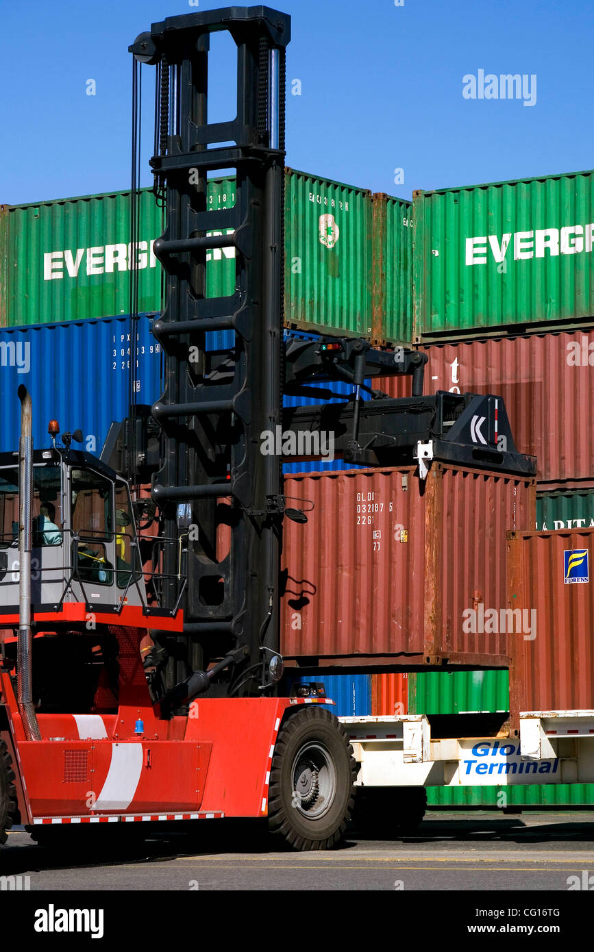 Using a specialized lift, maritime cargo container is stacked for ...