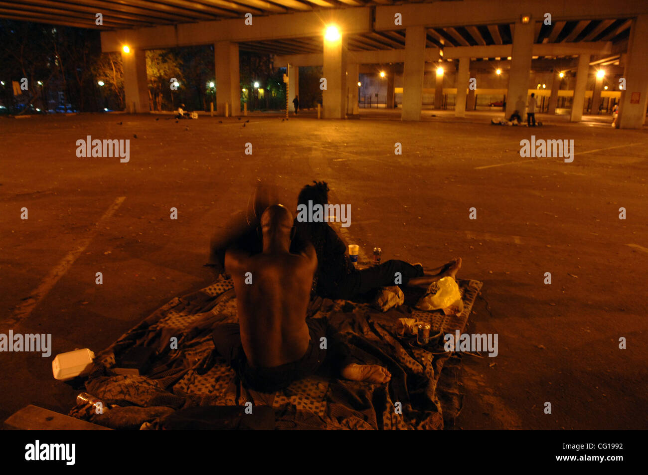 Homeless couples settle in for the night in an empty car park ...