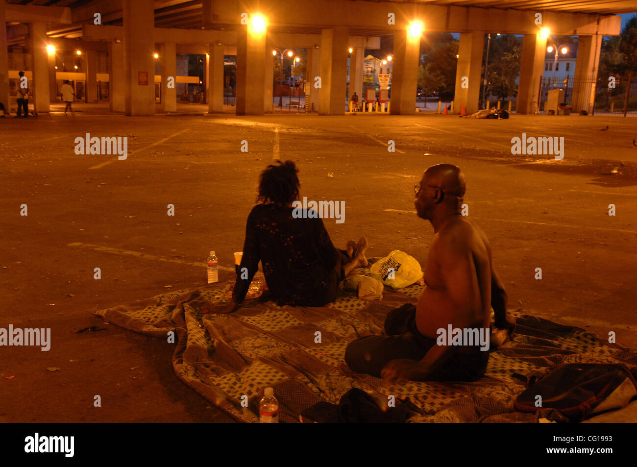 Homeless couples settle in for the night in an empty car park ...