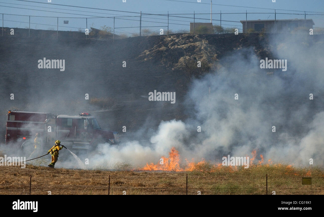 A Livermore-Pleasanton Fire Department firefighter helps put out a ...