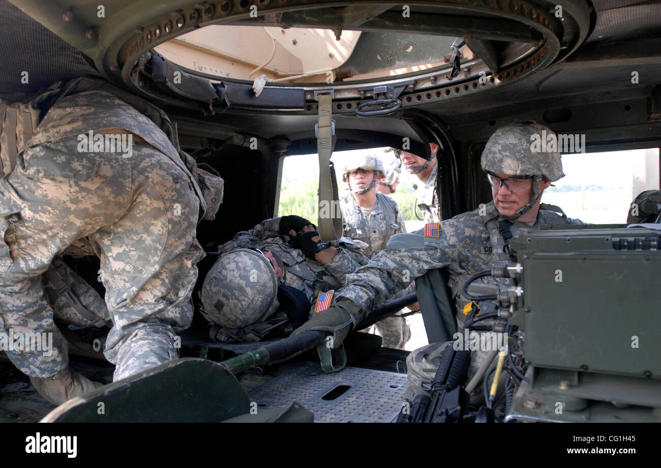 Sgt. Matt Convis (right) helps load a soldier into a humvee during a ...