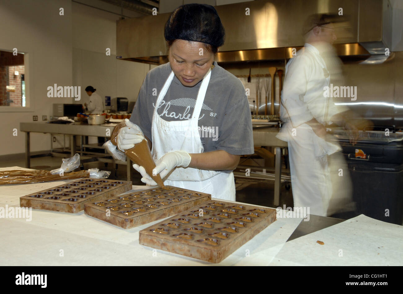 Hack Phetian fills chocolate molds at the Charles Chocolate facility in ...
