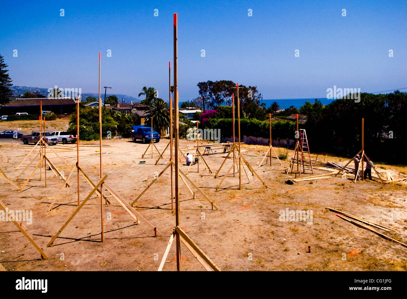A construction crew installs temporary "height poles" at a proposed ...