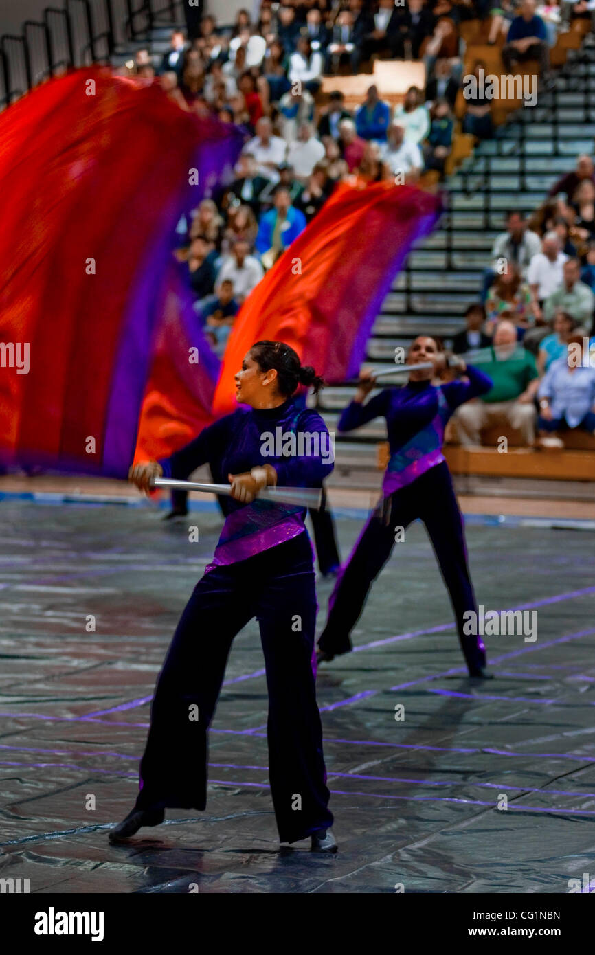 Twirling colorful banners to martial music, female color guard members ...