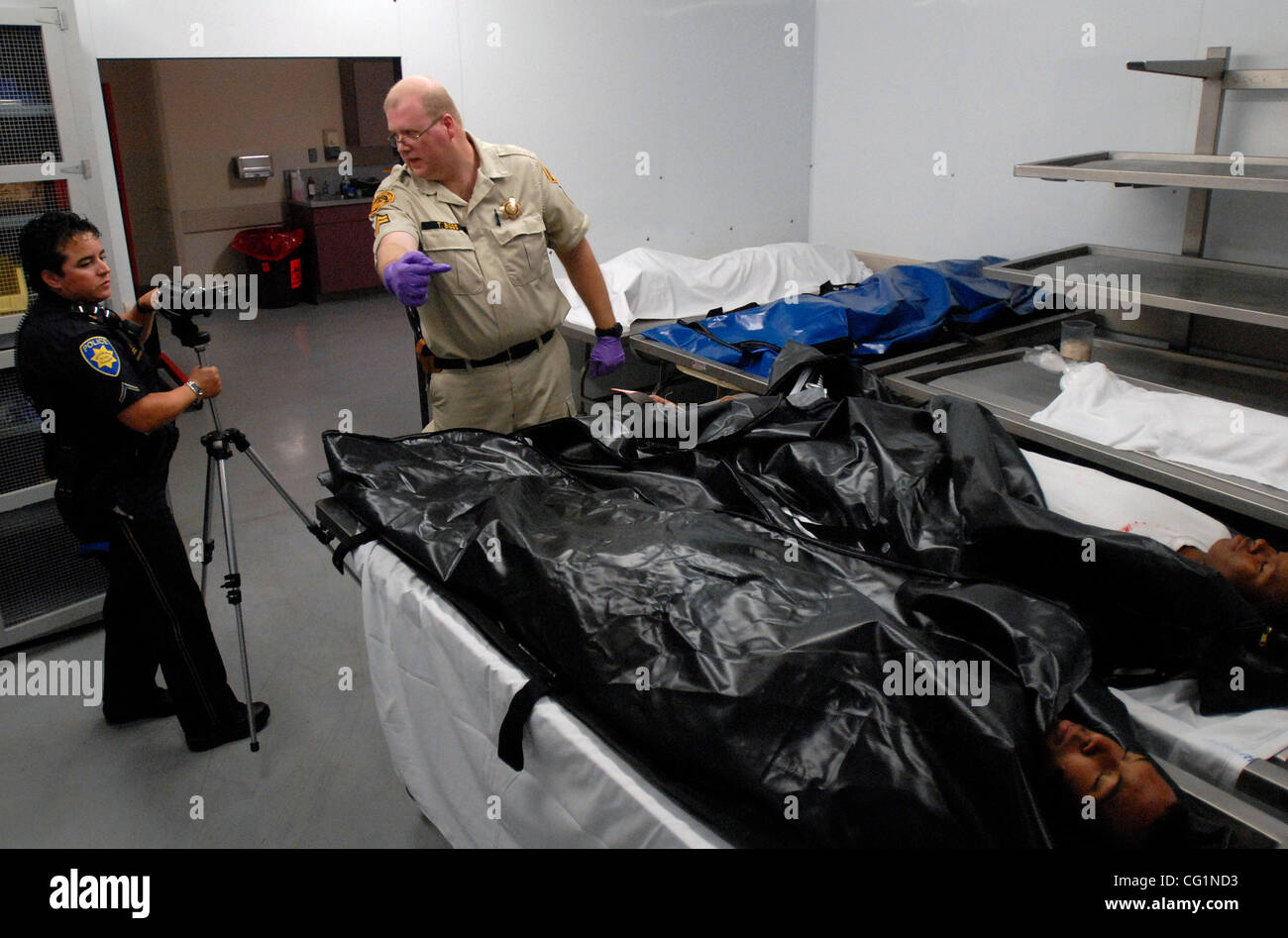 Gang officer, Donna Gianfala (left), works with Deputy Coroner's ...