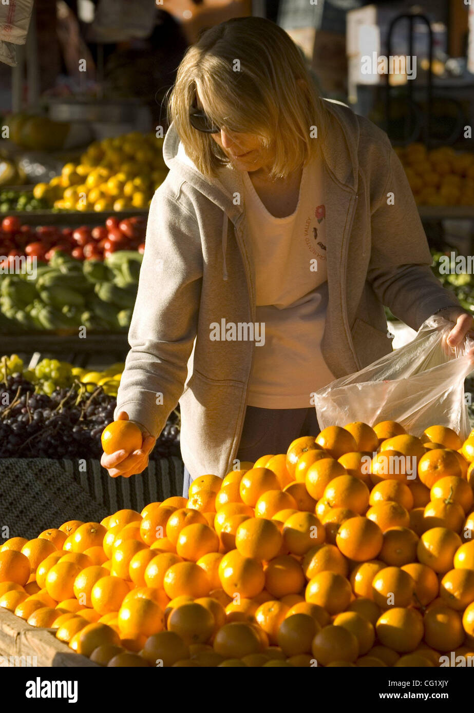 Gail Erwin (cq) of Galt chooses oranges Wednesday at the flea market ...