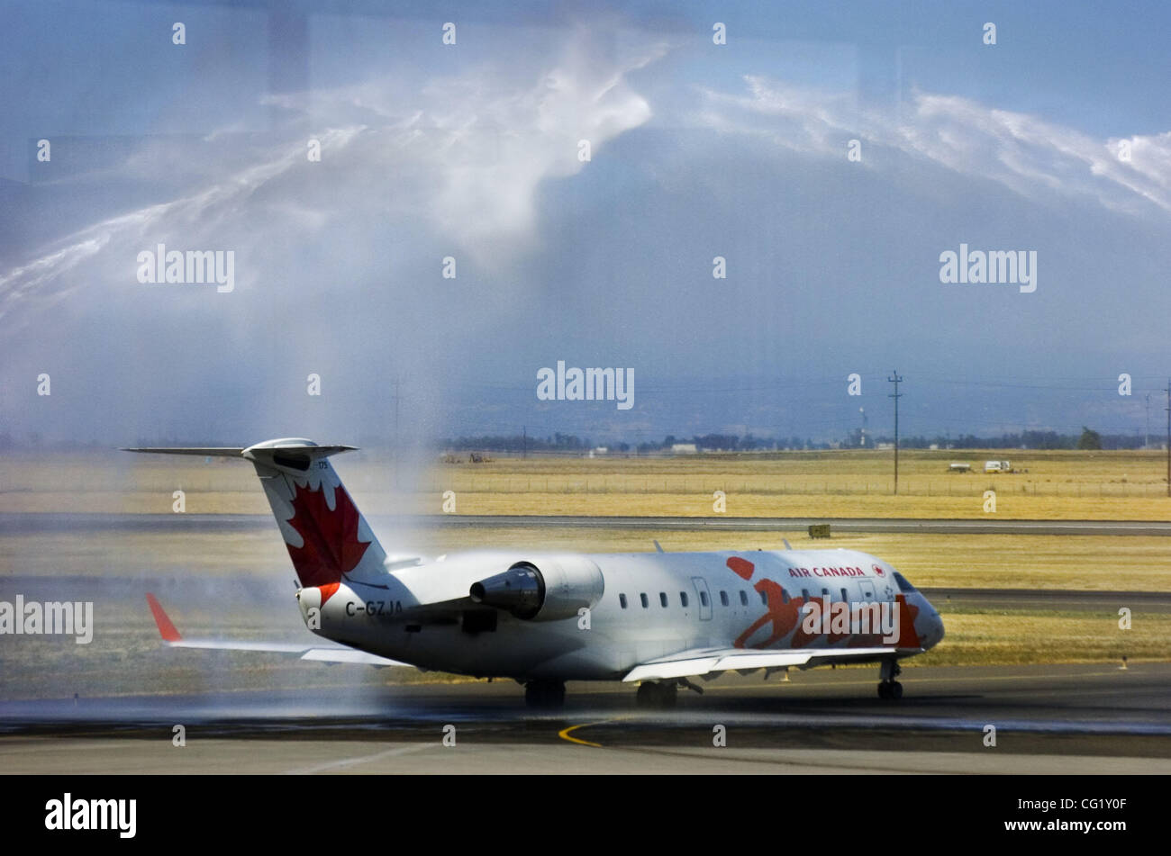 An Air Canada Jazz plane is showered with water by the Aircraft Rescue ...