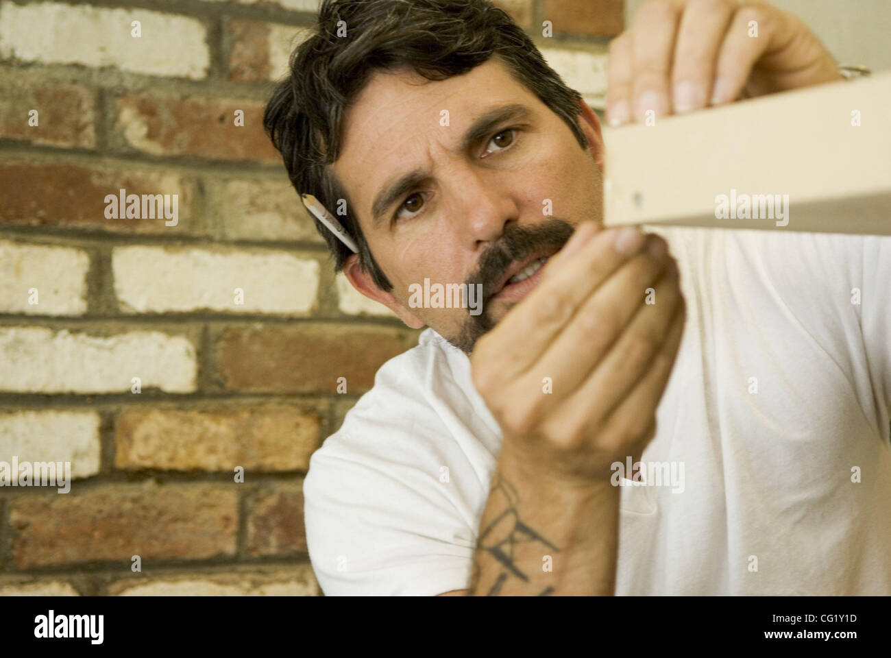 William Earle works in his Placerville home on a an exterior panel for ...