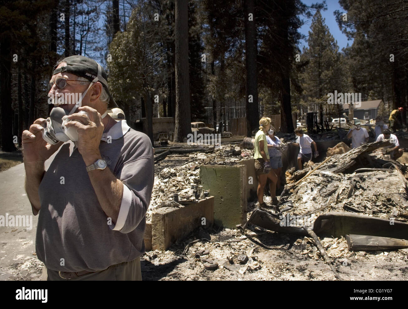 Warren Sprague puts on a mask outside his property where his home ...