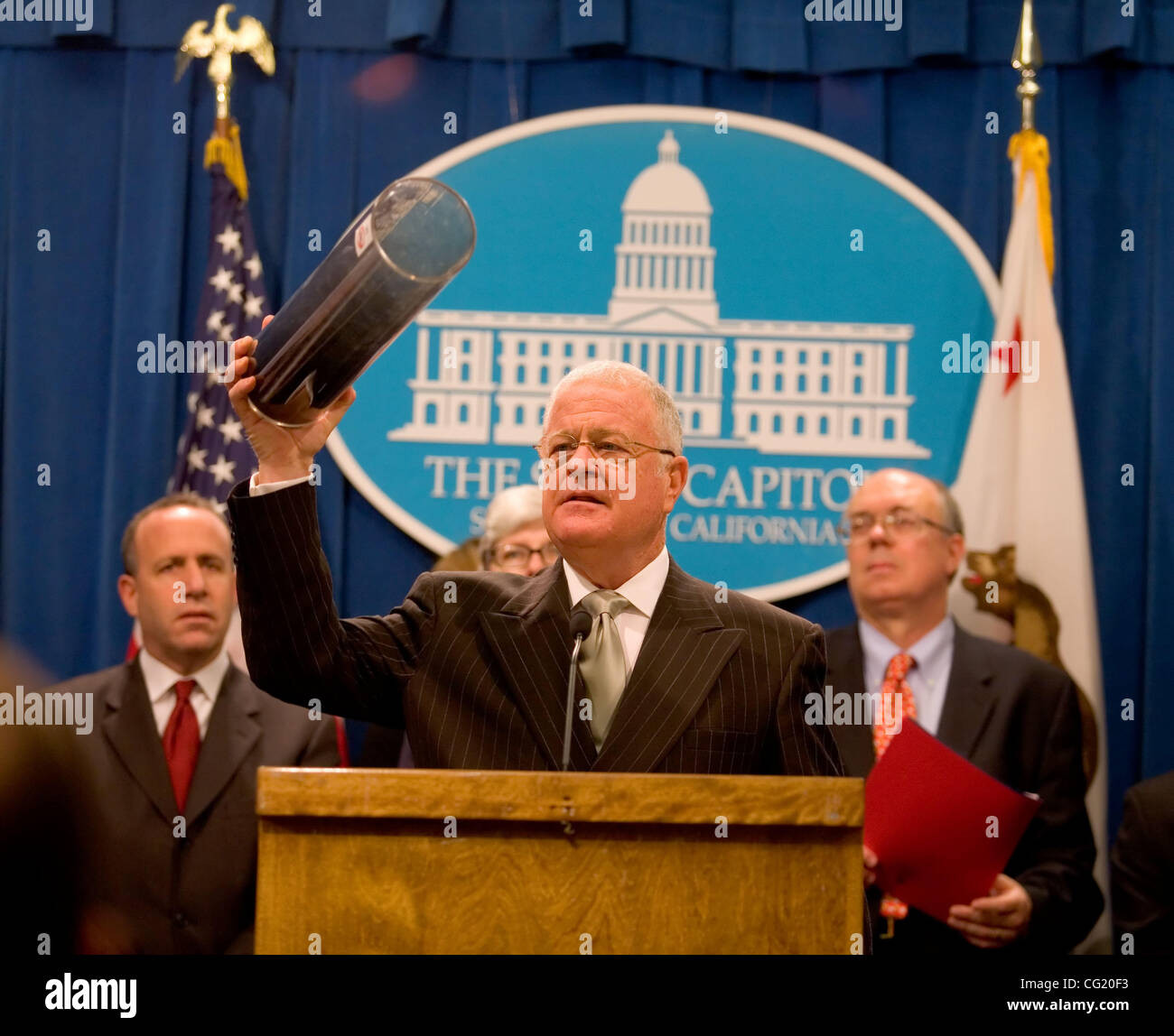 Senate Pro Tem, Don Perata, holds up a plastic vessel holding the solid ...