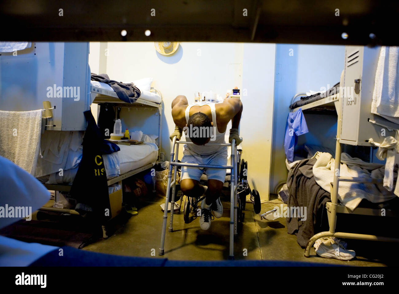 inmate Mark King, 50, does pushups using a walker next to his bunk ...
