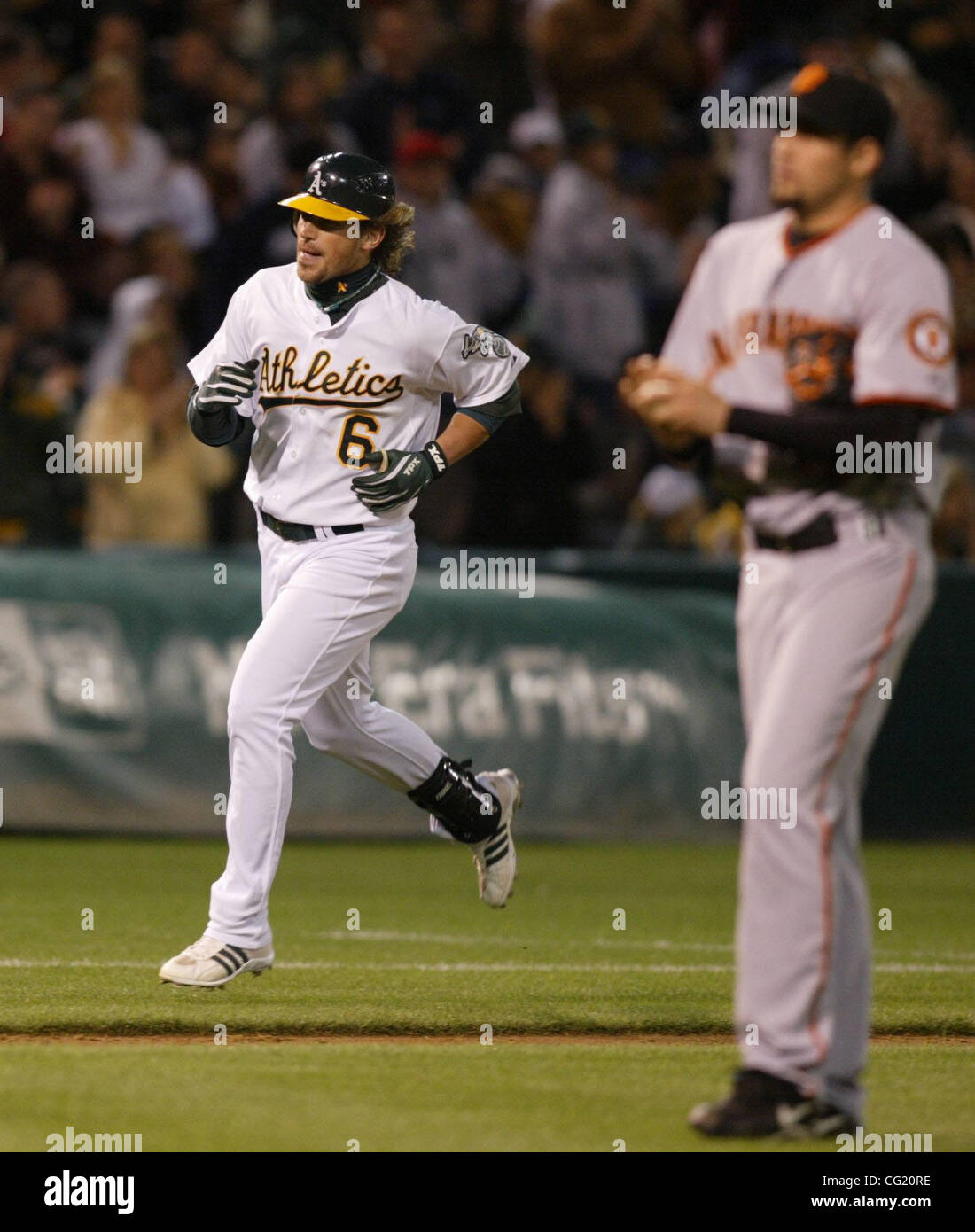 A's hitter Travis Buck rounds third and heads home after hitting a ...