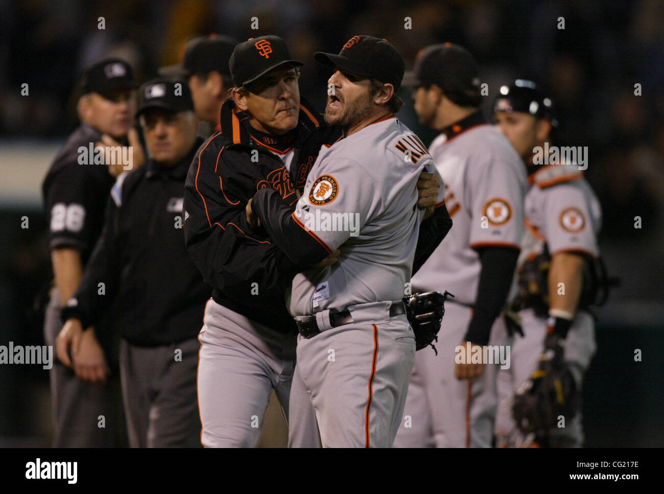 Giants pitching coach David Righetti holds back Steve Kline as he goes ...