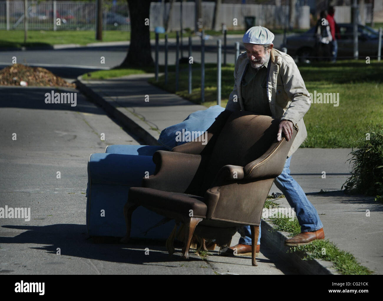 Ron Emslie moves some chairs to the curb that were illegally dumped on ...