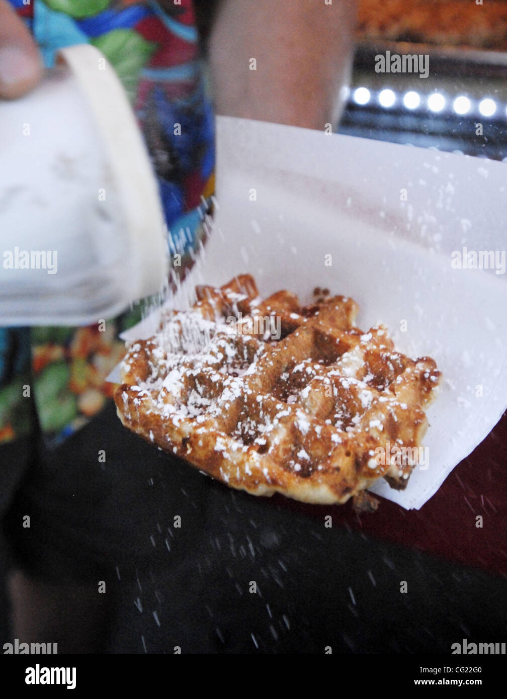 Marc Van Mieghem (cq) sprinkles powdered sugar on a belgian waffle ...