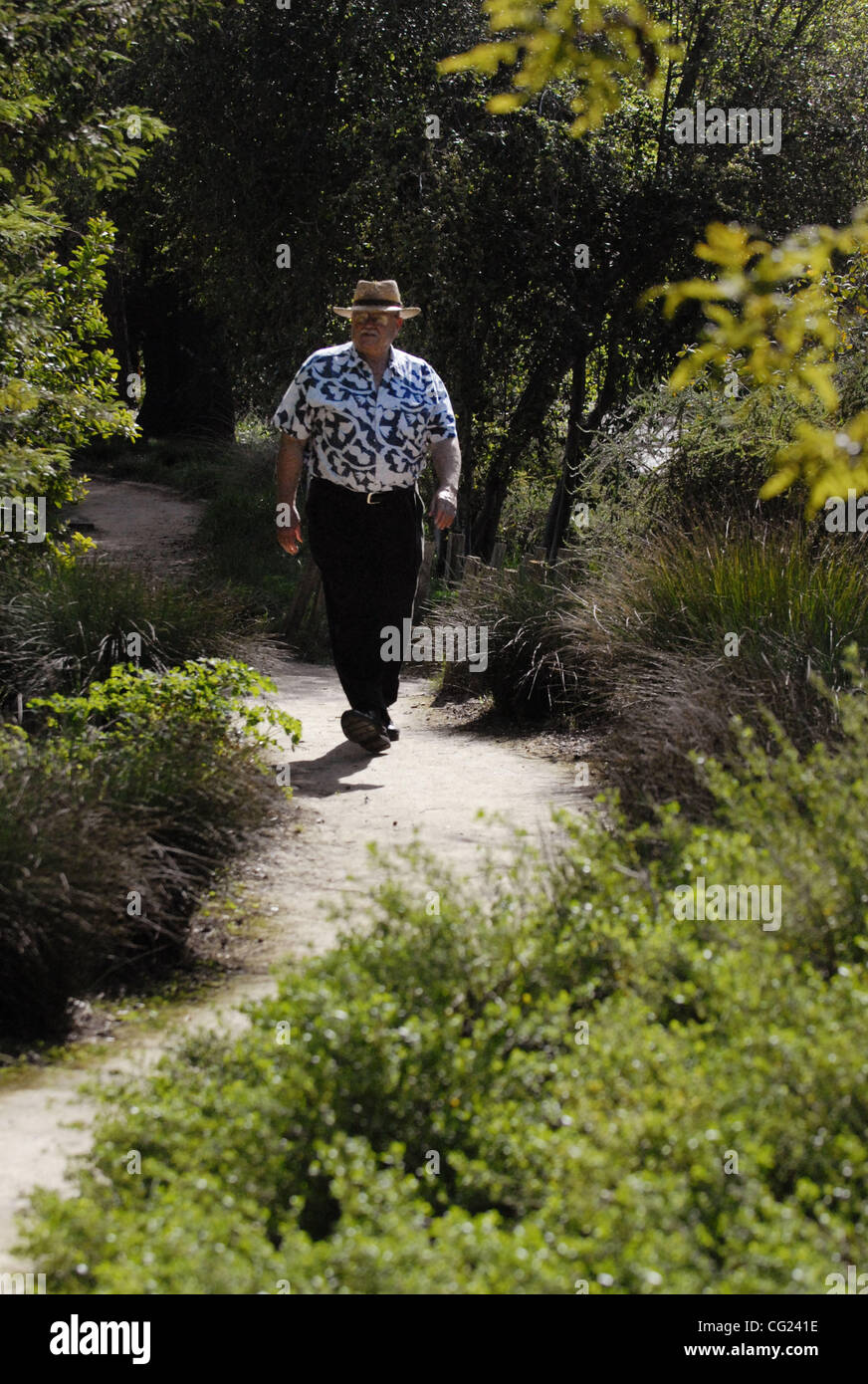 Warren Roberts walks toward the photographer along a pathway through ...