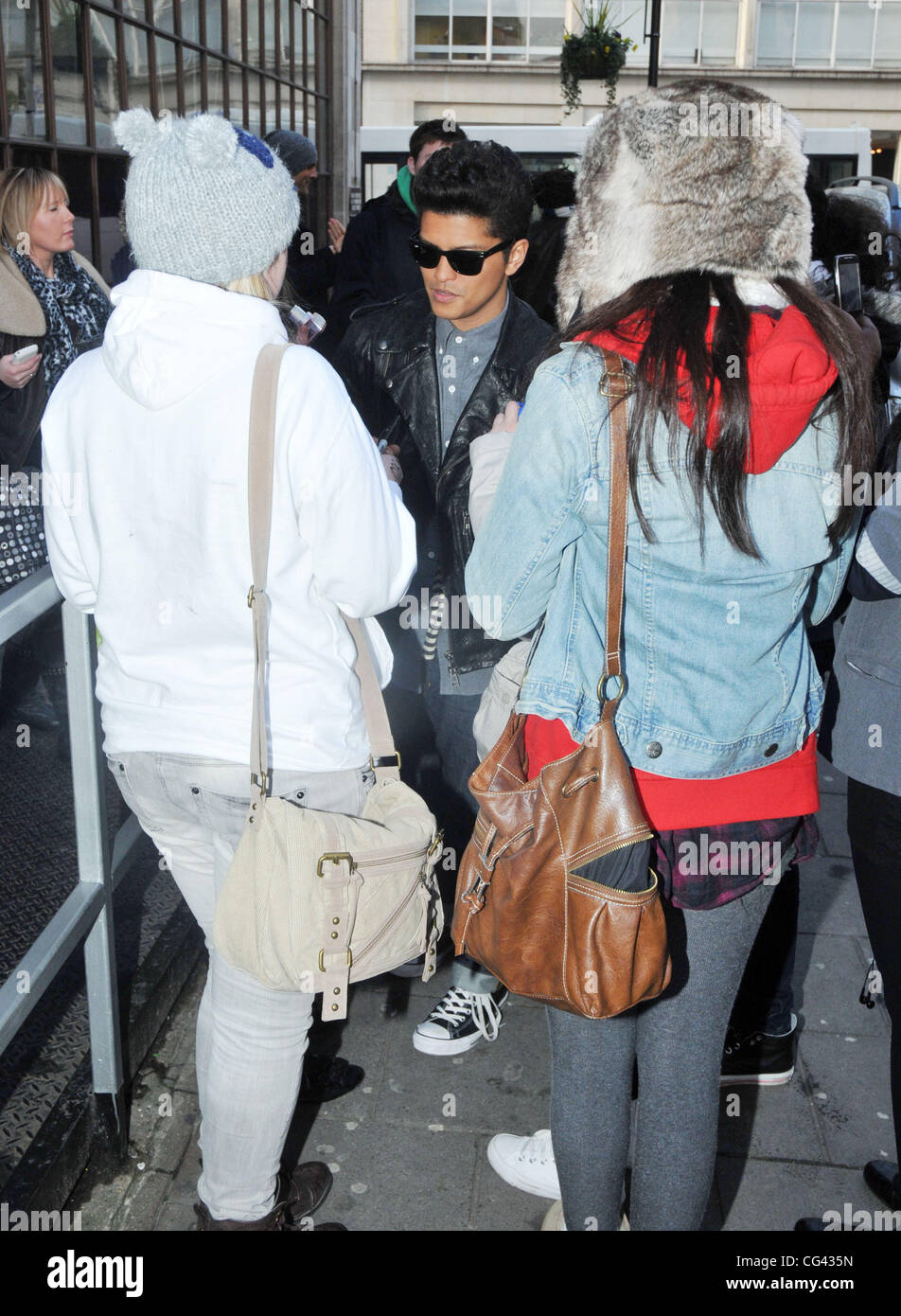 Bruno Mars signs autographs for fans as he arrives at the BBC Radio One ...