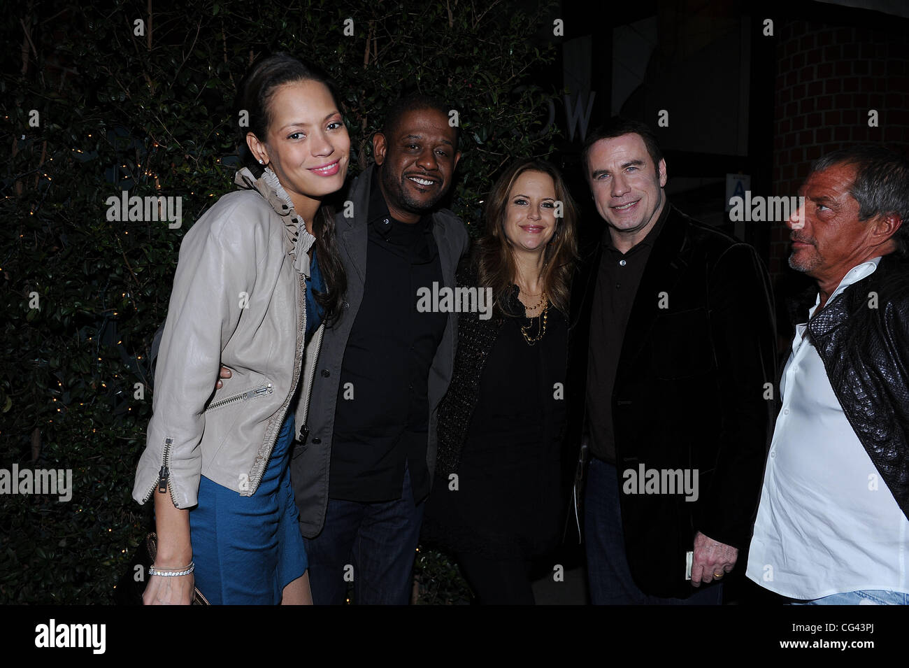 Kelly Preston and John Travolta posing for photos outside Mr Chow ...
