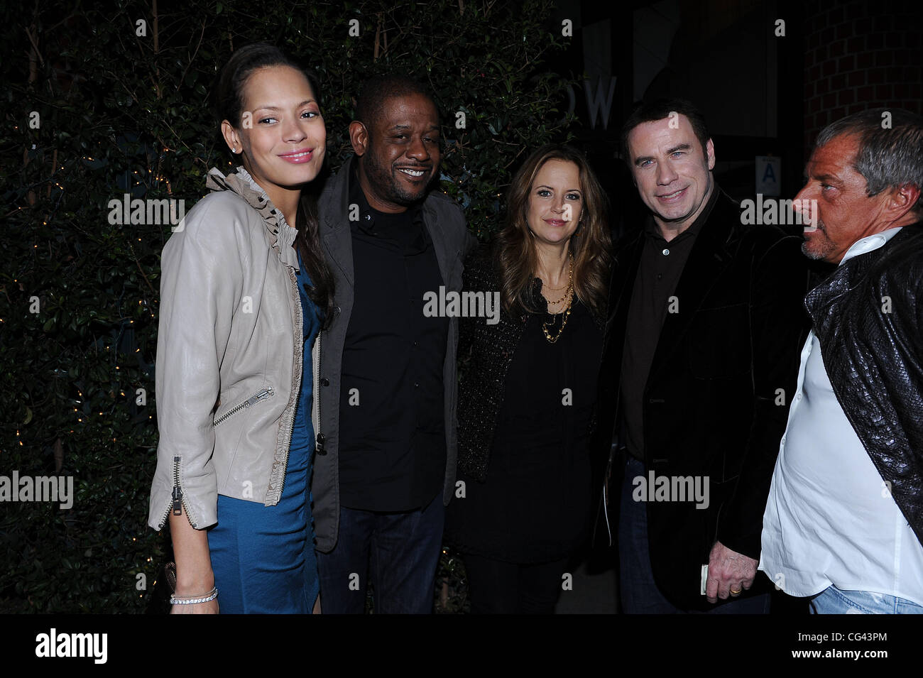 Kelly Preston and John Travolta posing for photos outside Mr Chow ...