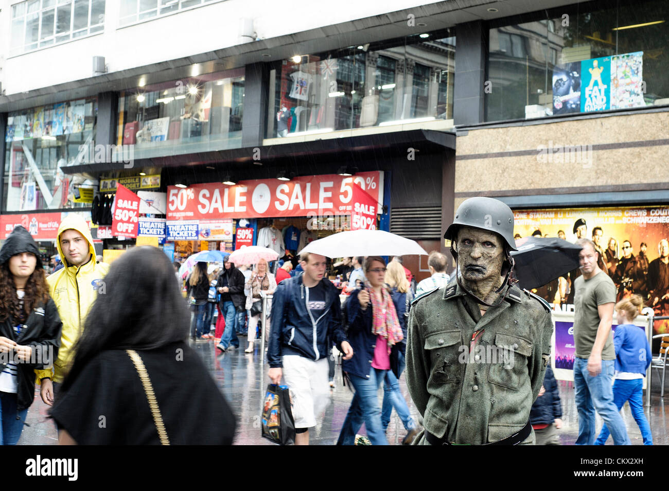 Nazi Zombies stand in the rain as people walk past with umbrellas in ...