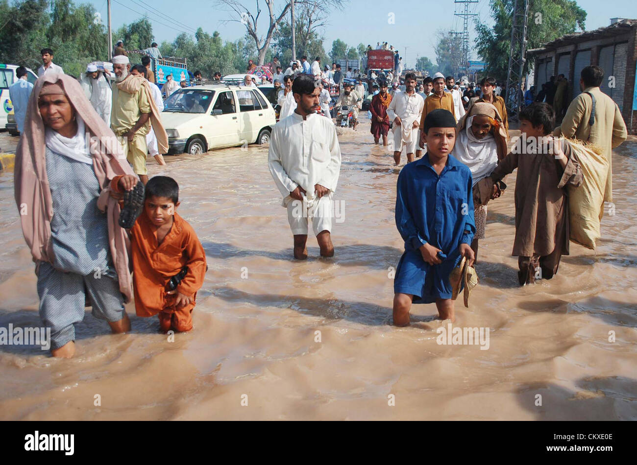 People pass through flood water during heavy downpour of Monsoon Season ...
