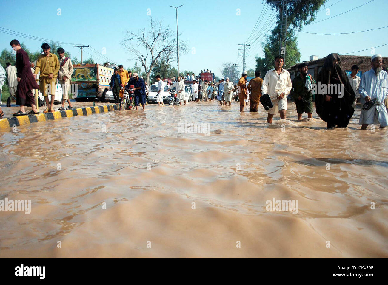 People pass through flood water during heavy downpour of Monsoon Season ...