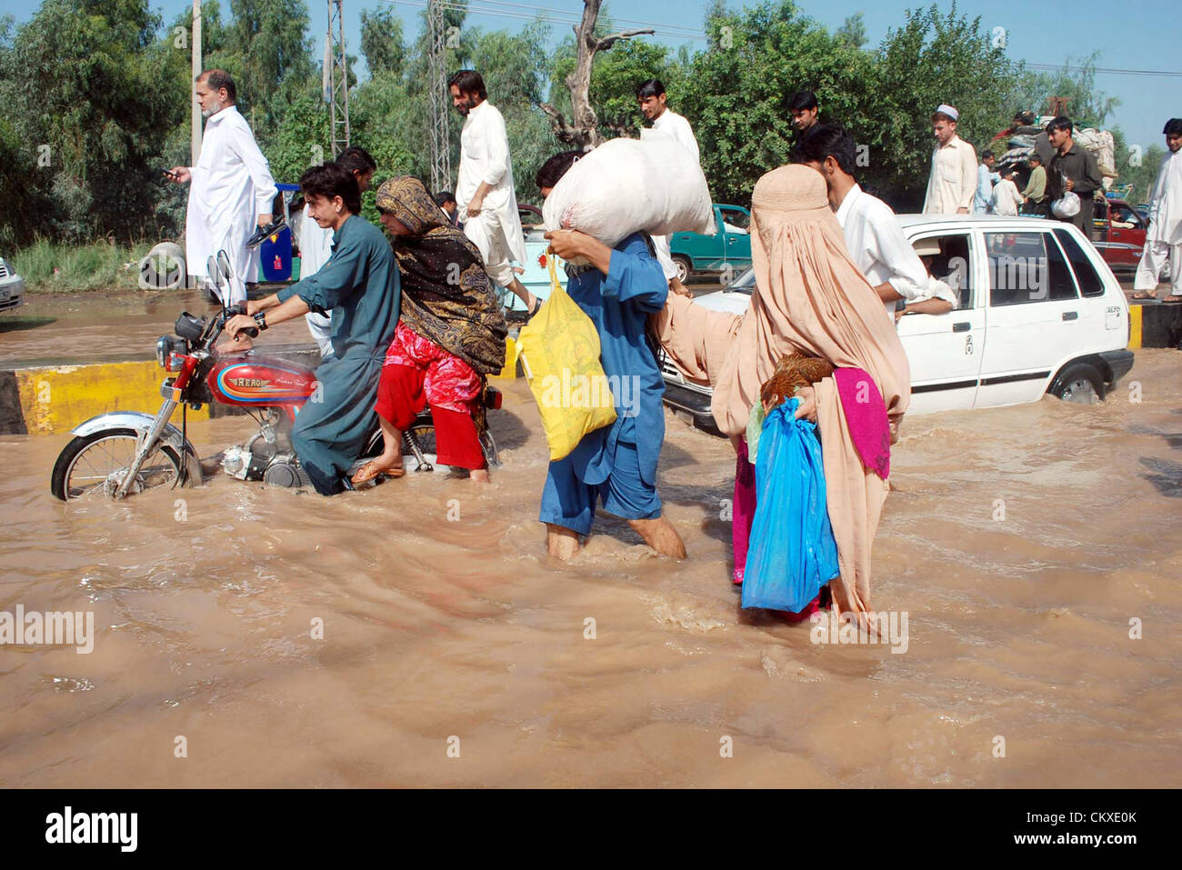 People pass through flood water during heavy downpour of Monsoon Season ...